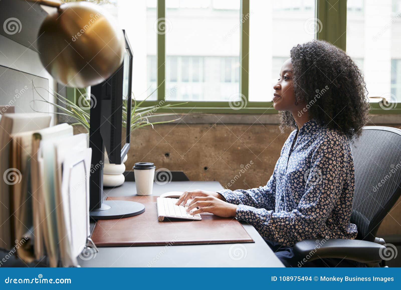 Black Woman Working at a Computer in an Office, Side View Stock Photo ...
