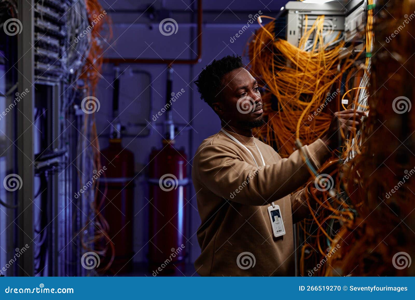 Black Young Man As System Administrator Working with Server in Neon ...