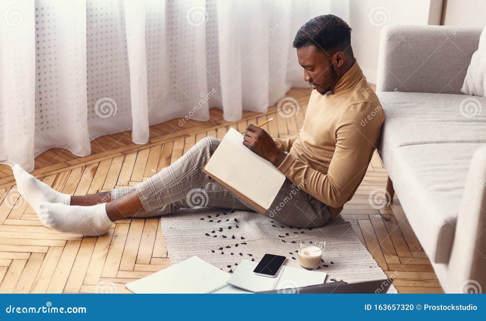 Young Man Taking Notes Studying Sitting on Floor at Home Stock Photo ...