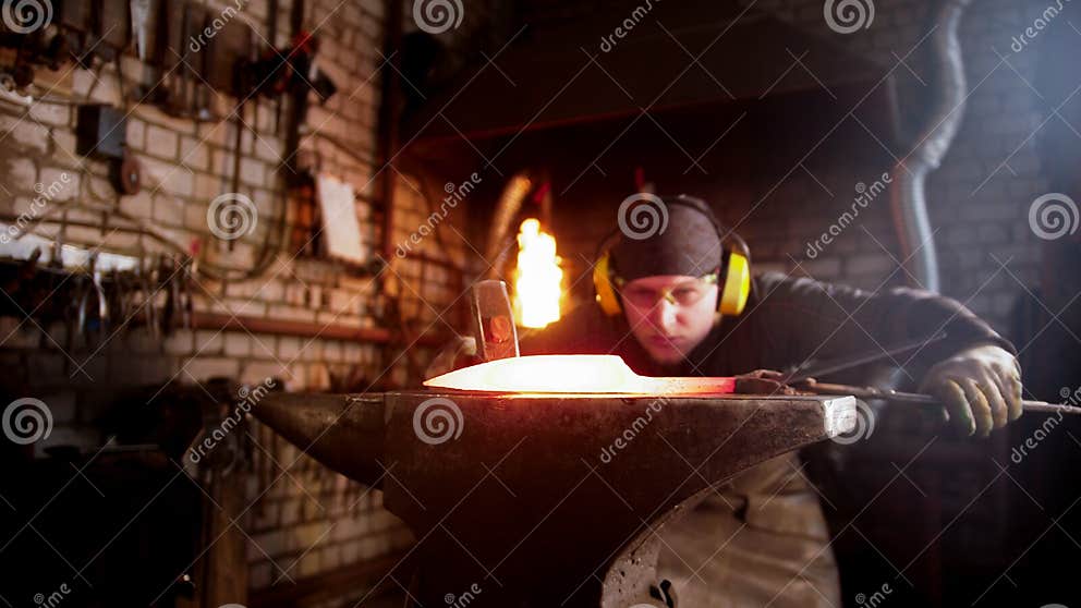Blacksmith Forging a Knife Blade in Workshop Using a Hammer Stock Photo ...