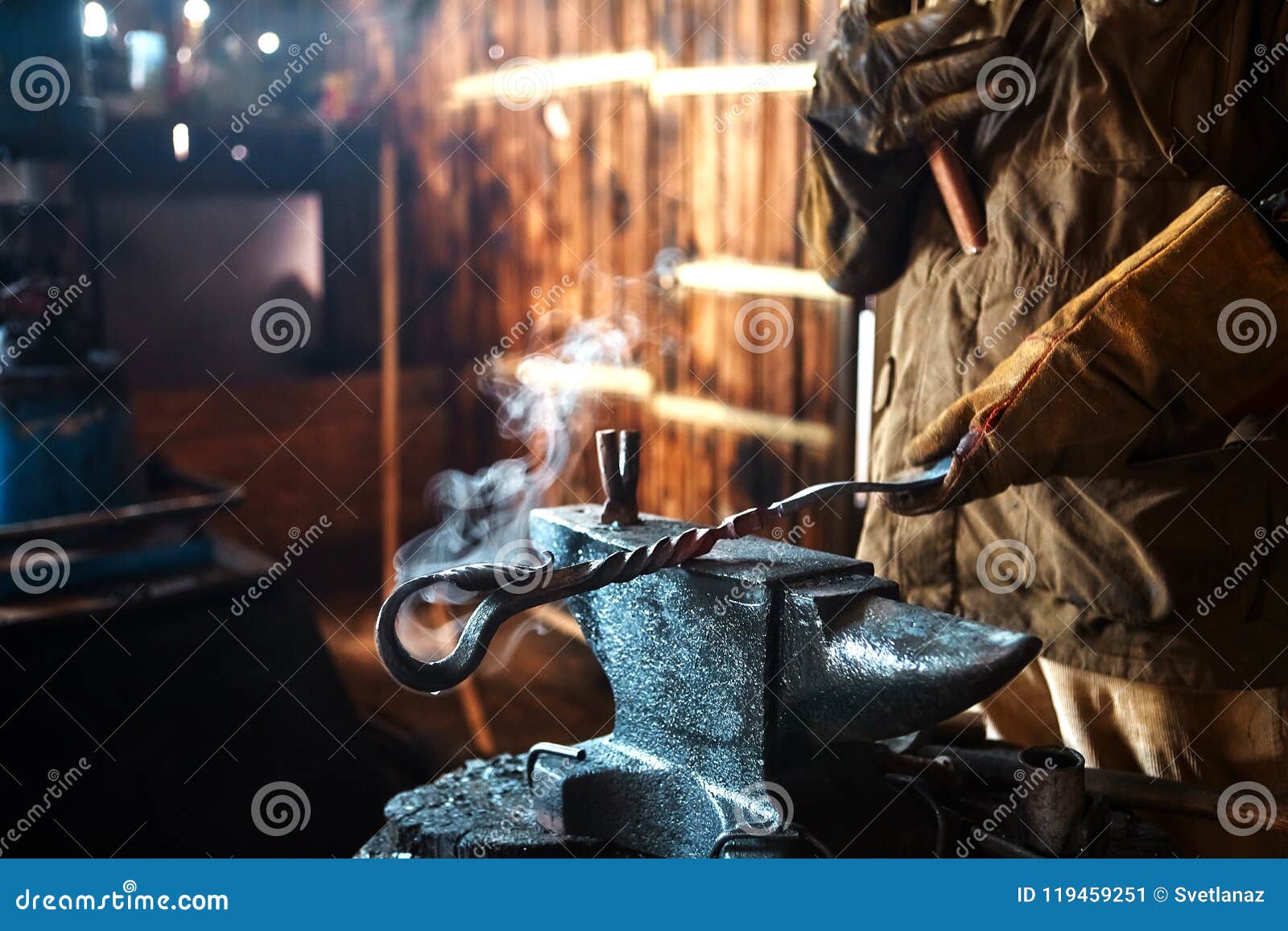The Blacksmith Forging the Molten Metal on the Anvil in Smithy. Stock ...