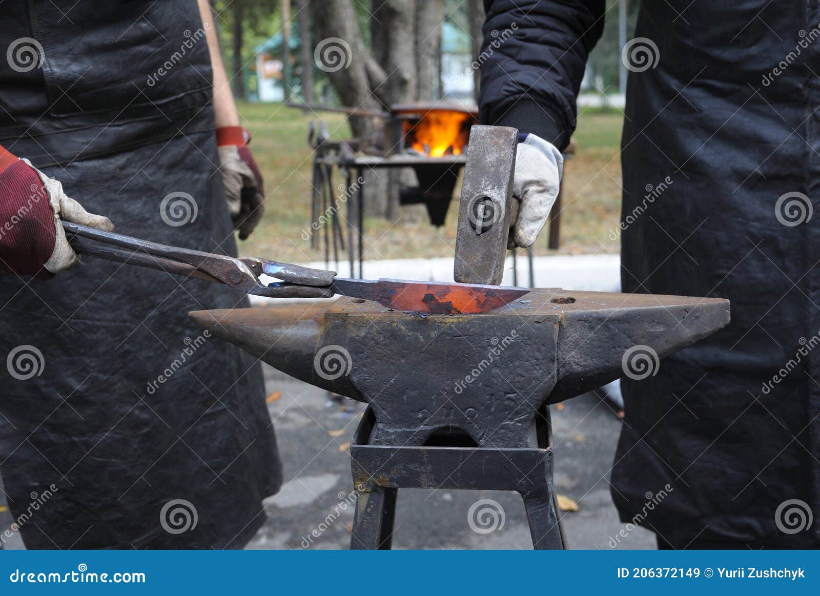 Blacksmith Hands Holding Forceps and a Hammer Forging a Metal Billet ...