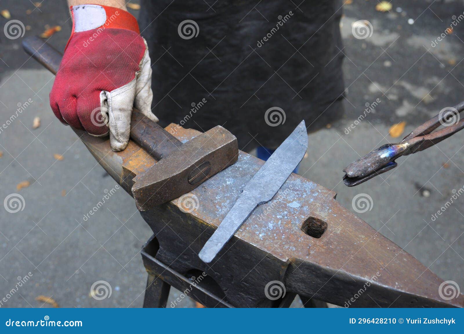Blacksmith Hands Holding Forceps and a Hammer Forging a Metal Billet ...