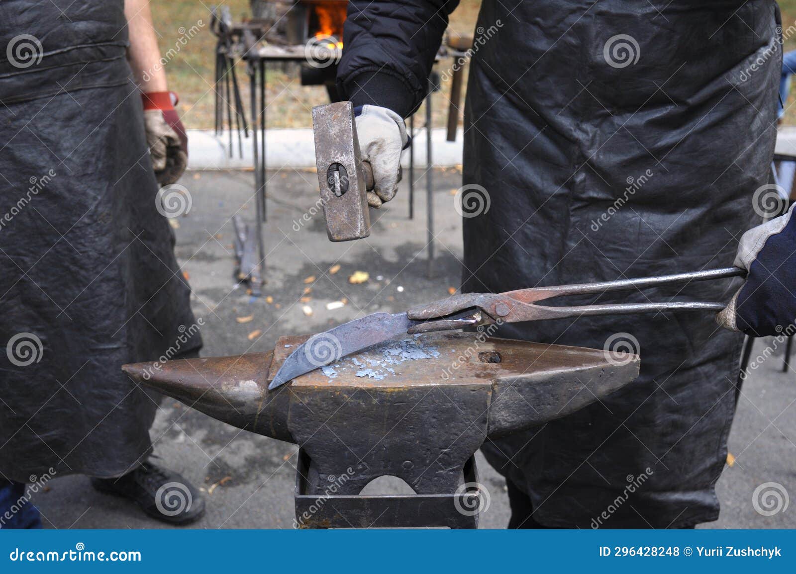 Blacksmith Hands Holding Forceps and a Hammer Forging a Metal Billet ...