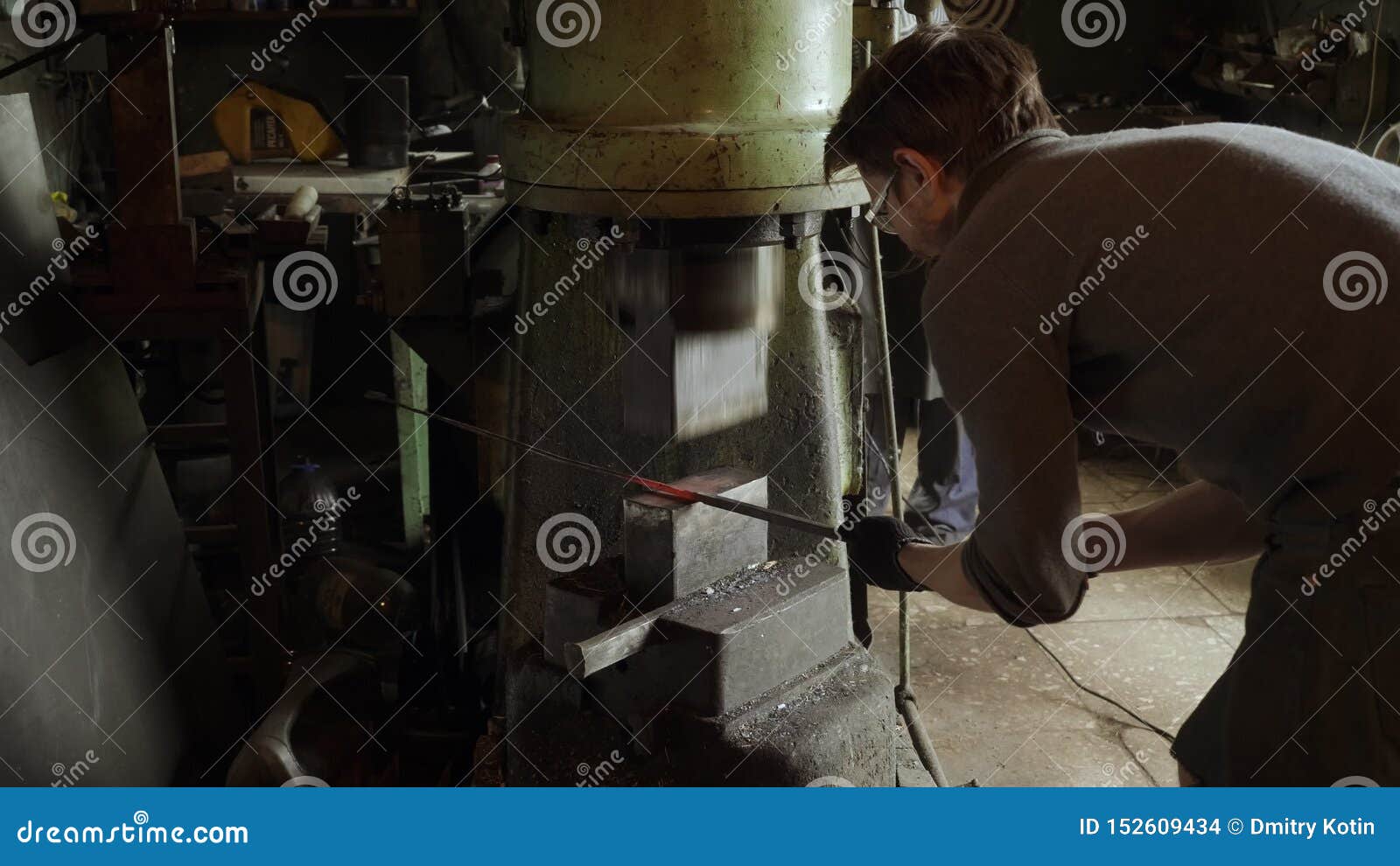 Blacksmith Holding Candent Iron Ingot and Forging it Using Pneumatic ...