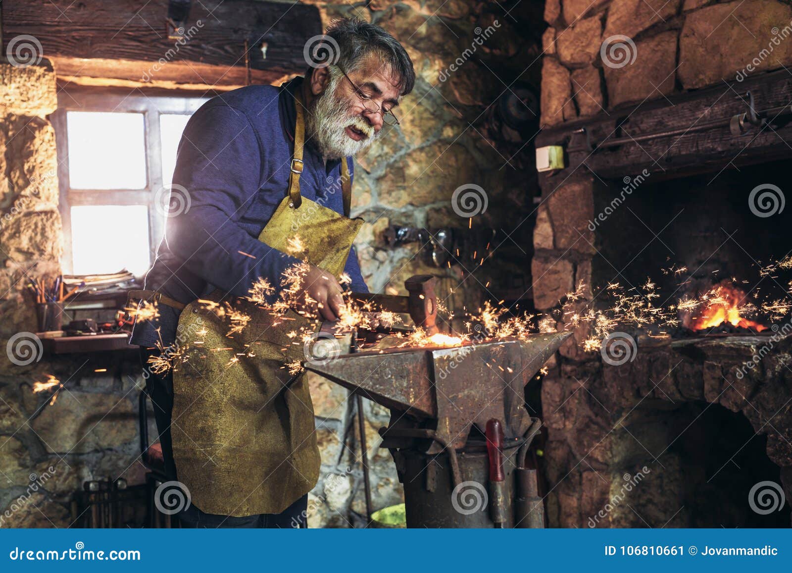 Blacksmith Manually Forging The Molten Metal On The Anvil In Smithy ...