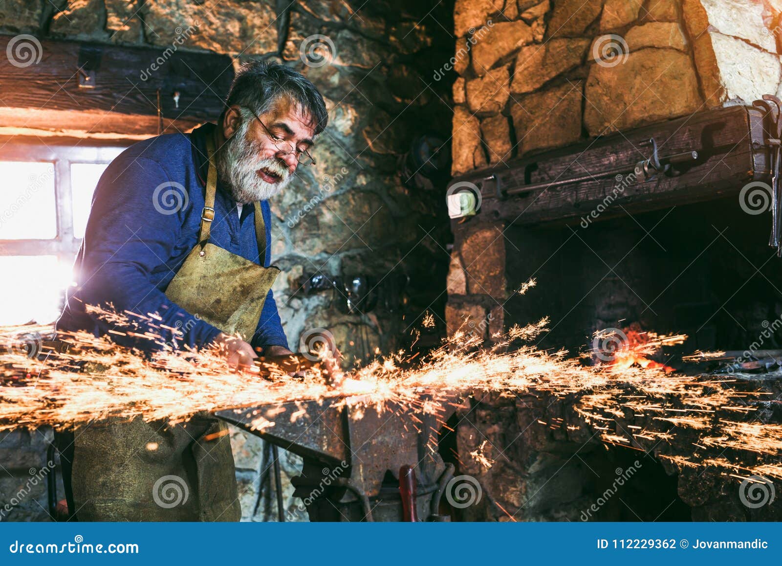 Blacksmith Manually Forging The Molten Metal On The Anvil In Smithy ...