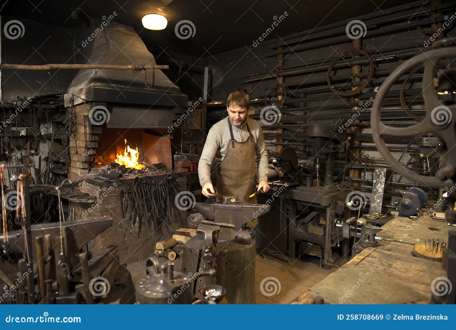 The Blacksmith Manually Forging the Red-hot Metal on the Anvil in ...