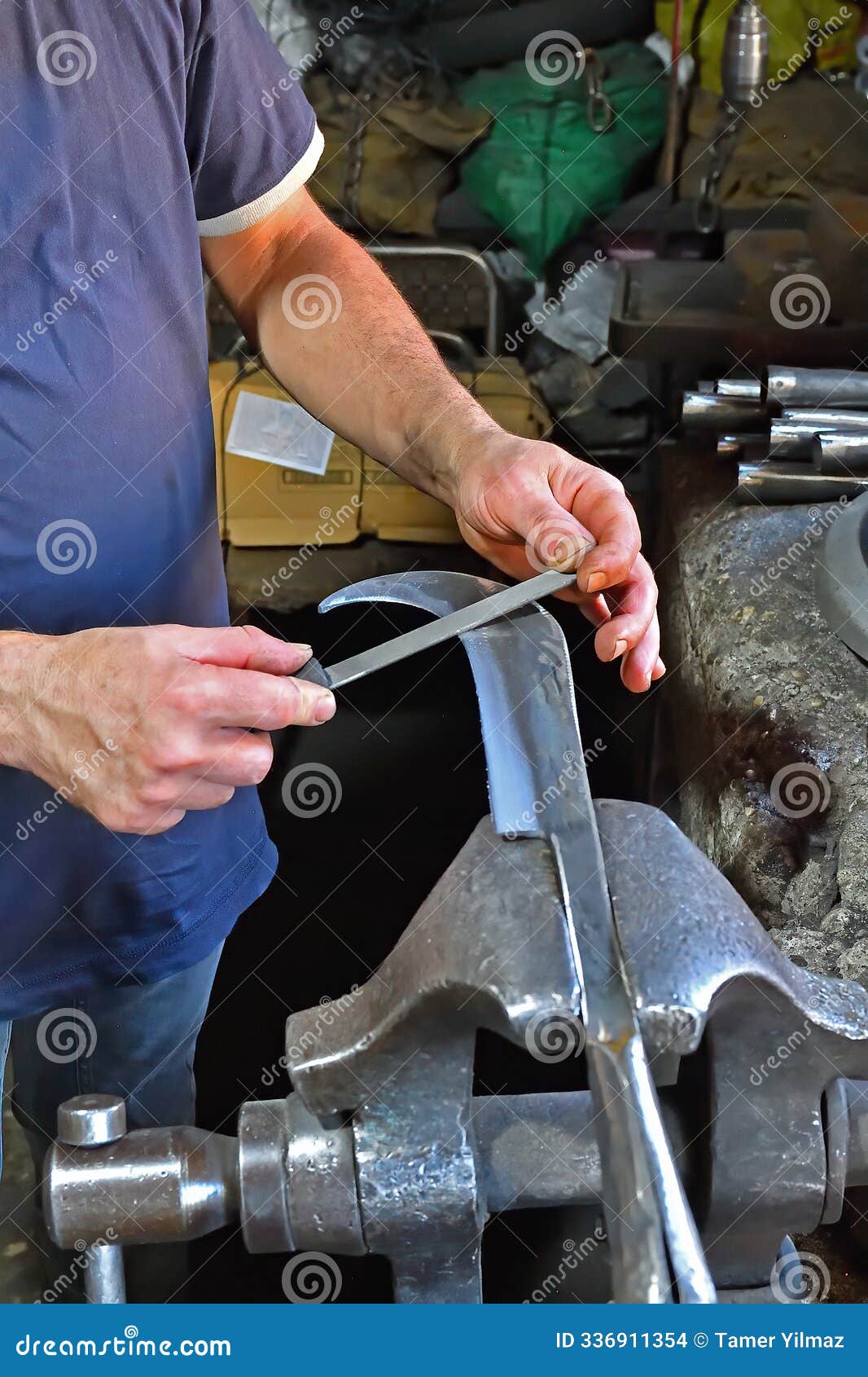 A Blacksmith Sharpens a Cutting Tool in a Blacksmith S Workshop. Stock ...