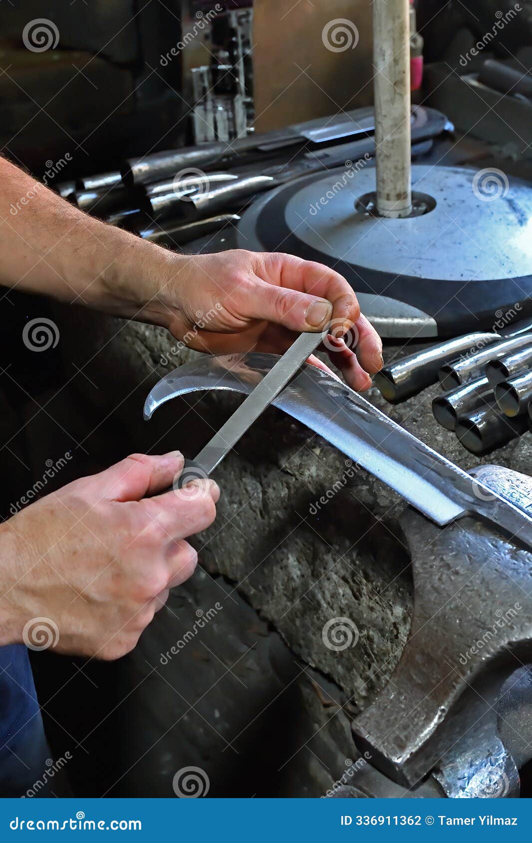 A Blacksmith Sharpens a Cutting Tool in a Blacksmith S Workshop. Stock ...