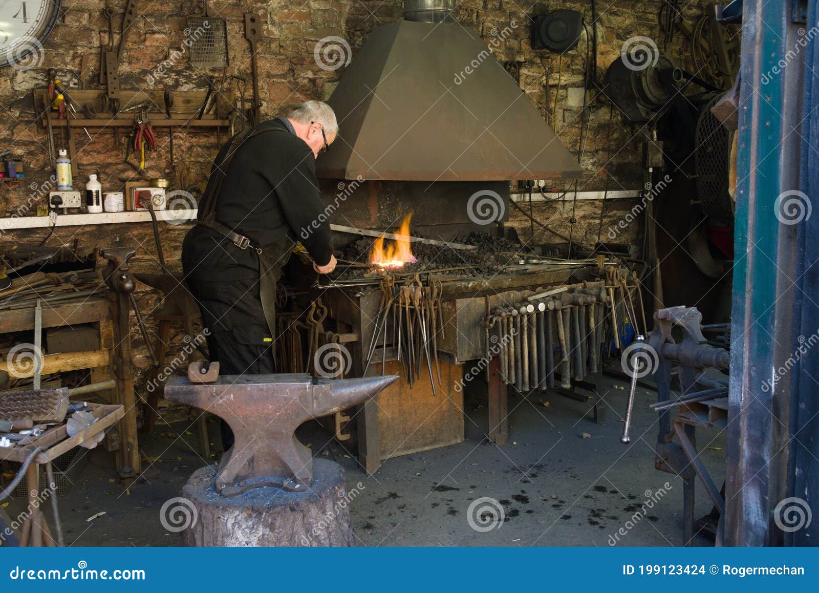 Blacksmith Working at His Forge with Metal in White Flame Editorial ...