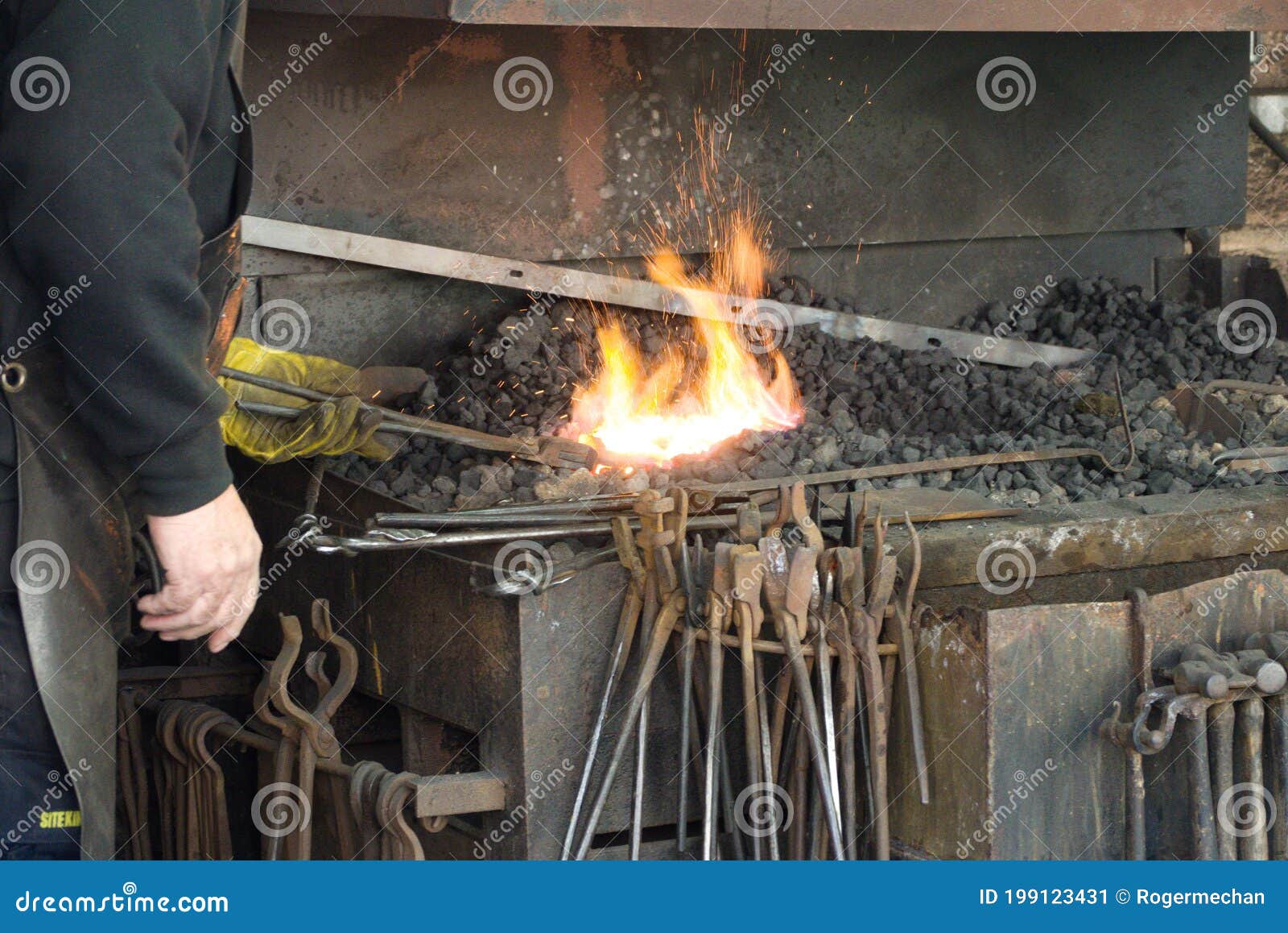 Blacksmith Working at His Forge with Metal in White Flame Editorial ...