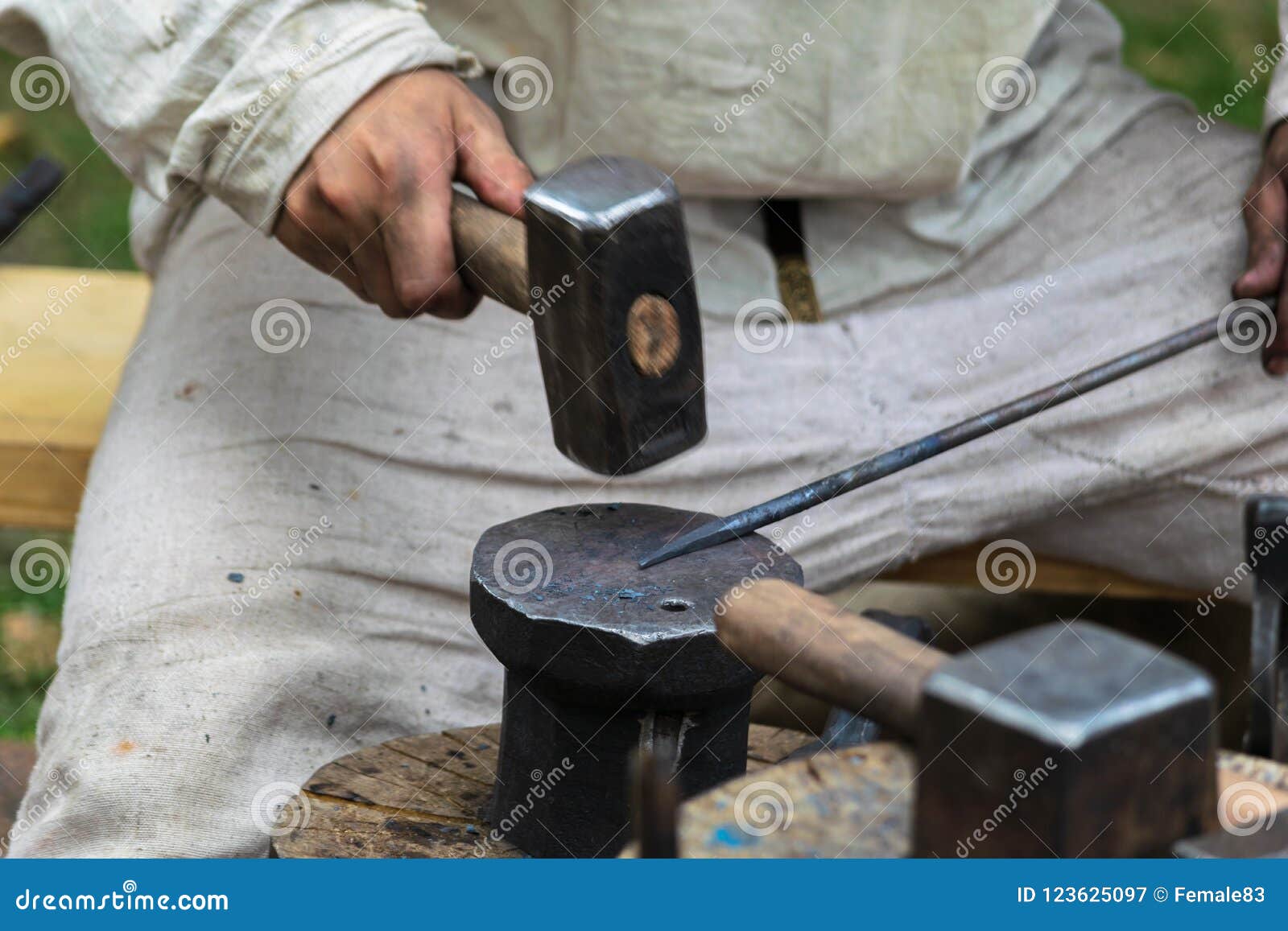 Blacksmithing, Blacksmith in White Cloth Hits Anvil with a Hammer Stock ...