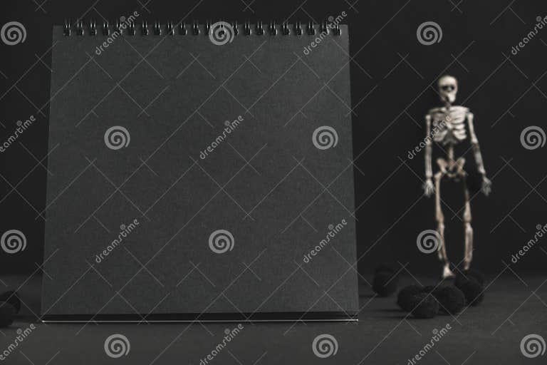 Blank Black Notebook on a Black Background with a Blurred Skeleton and ...