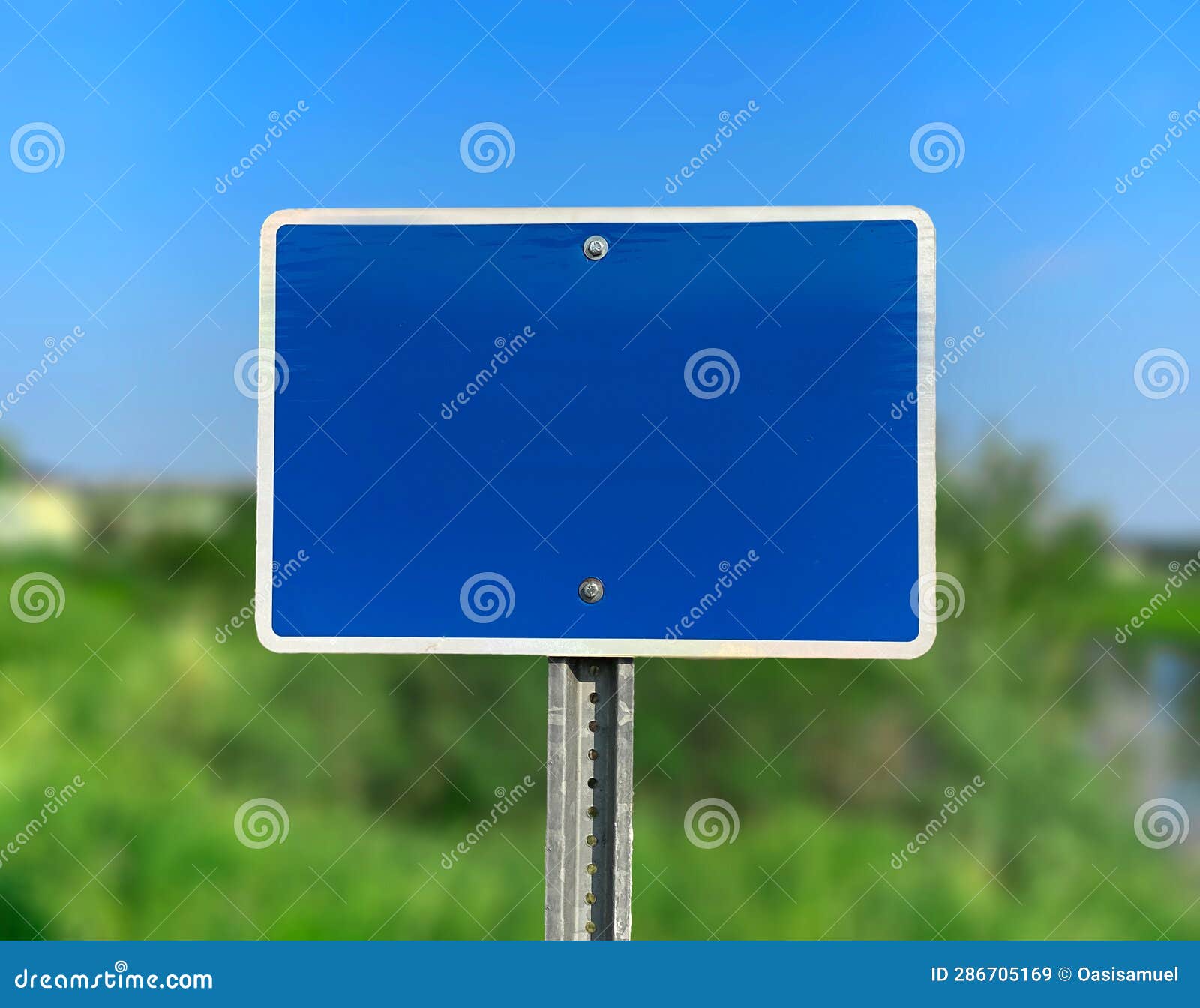 A Blank Empty Blue Sign with a Green Field and Blue Sky Background ...