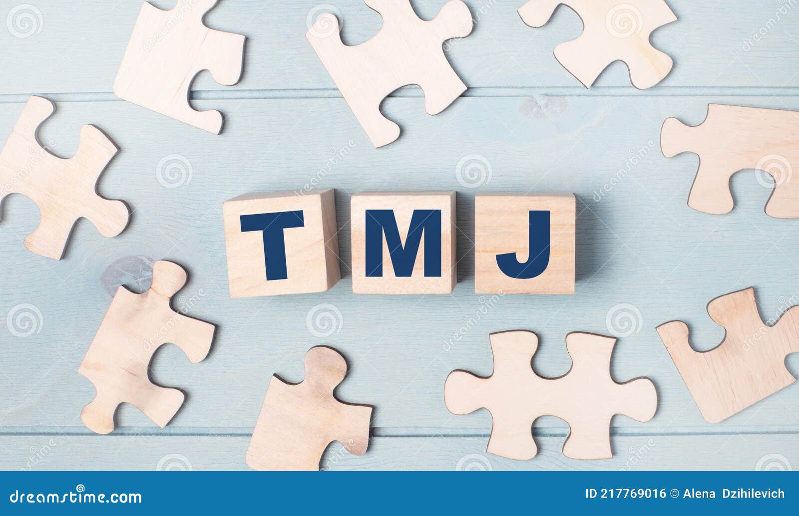 Blank Puzzles and Wooden Cubes with the Text TMJ Lie on a Light Blue ...