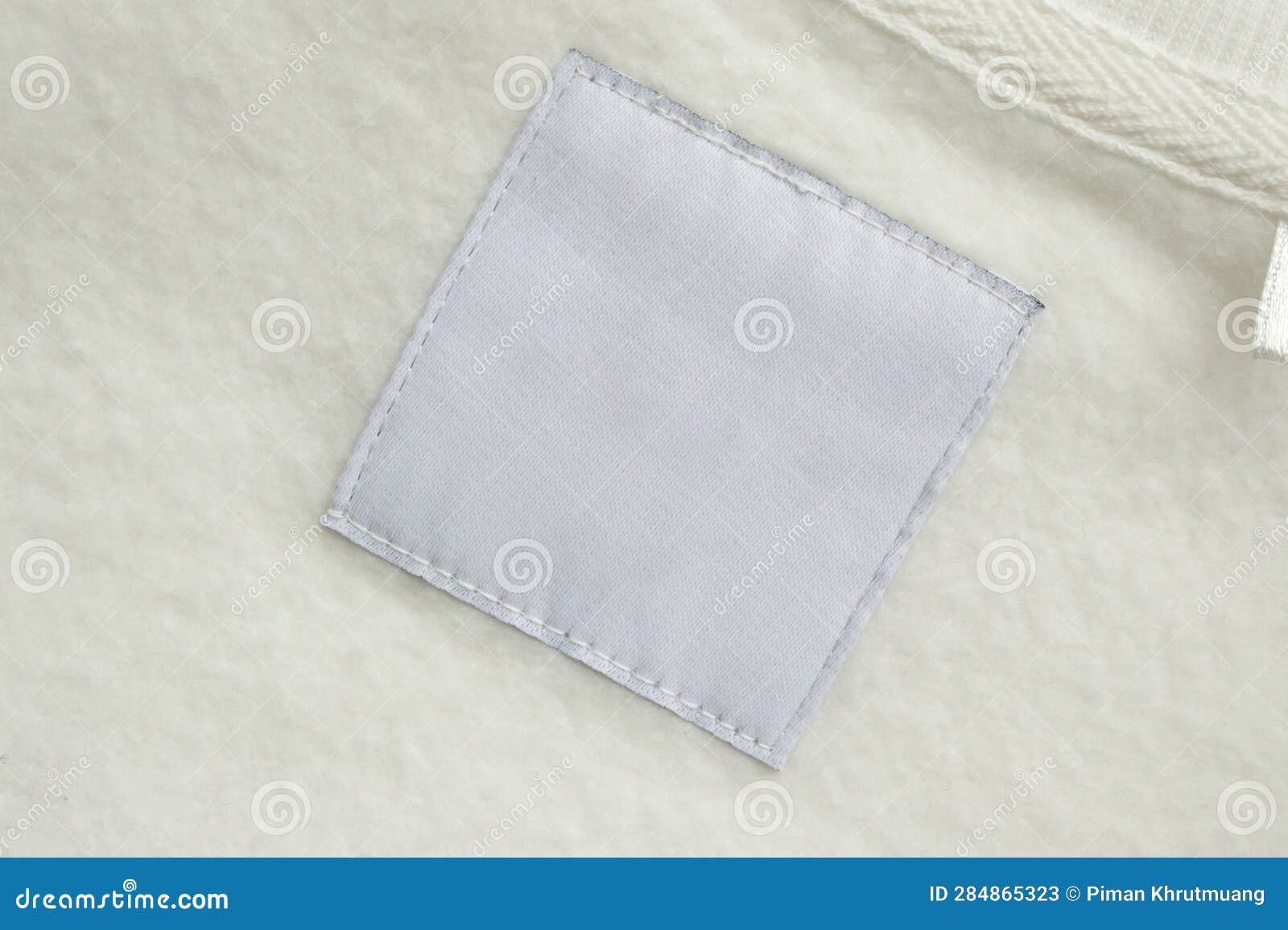Blank White Laundry Care Clothes Label on Fabric Texture Background ...