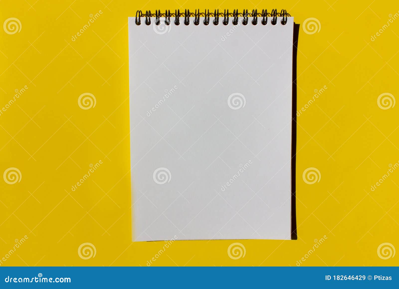 Blank White Notebook Page in a Spiral on a Bright Yellow Background ...