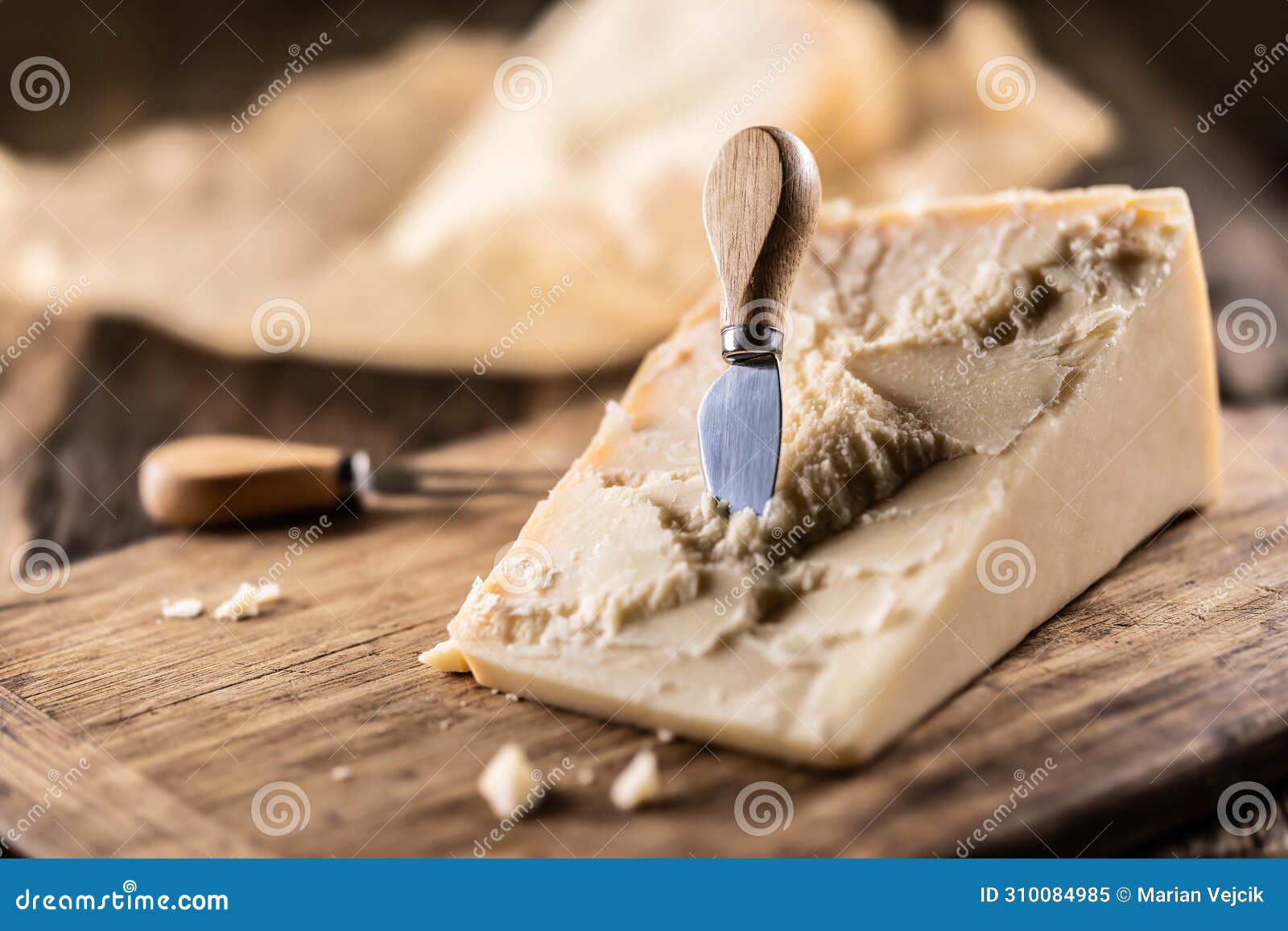 A Block and Pieces of Parmesan Cheese on a Cutting Board Along with a ...