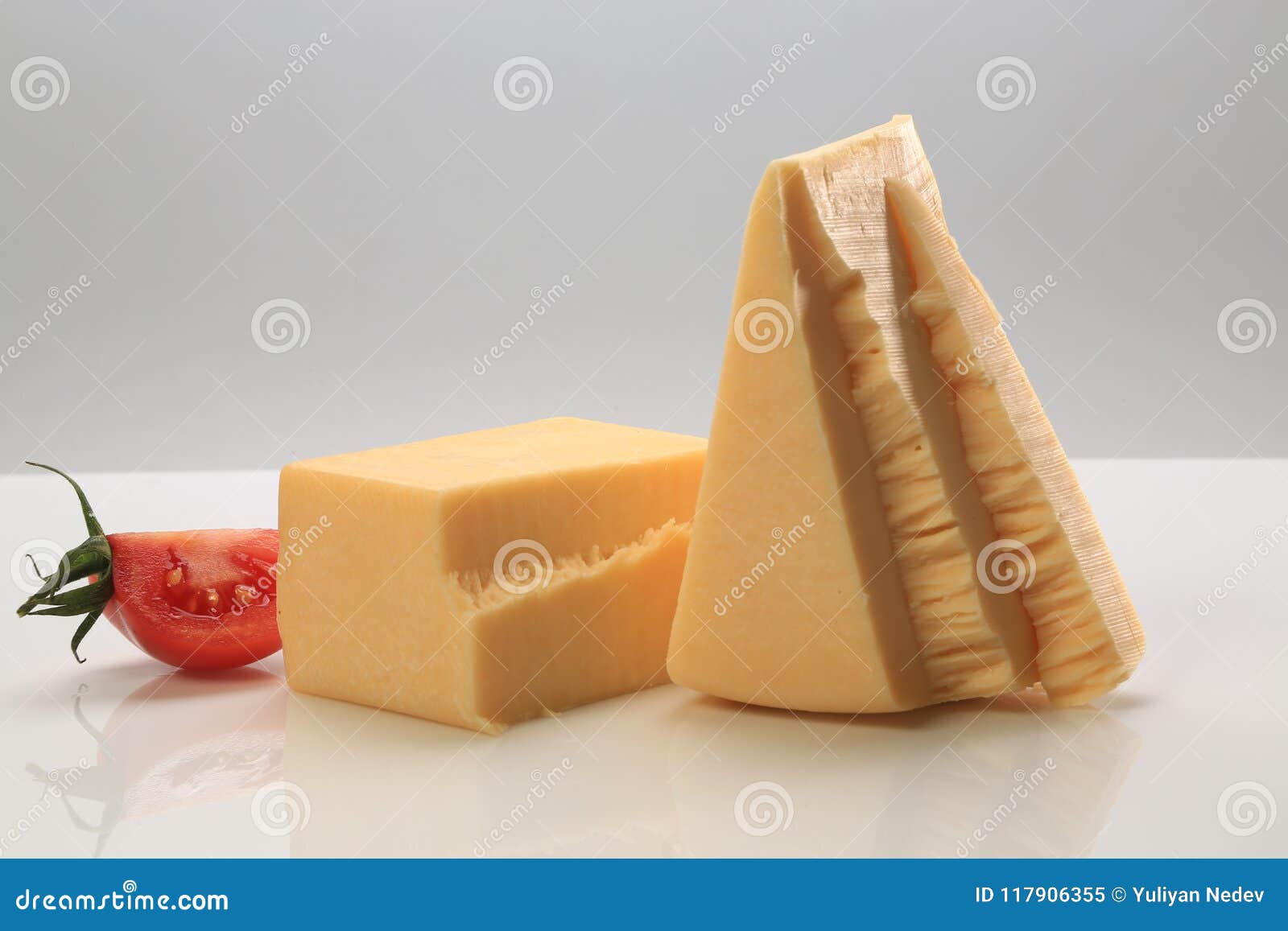 Block and Triangle Sliced Cheese with a Slice of Tomato Stock Image ...