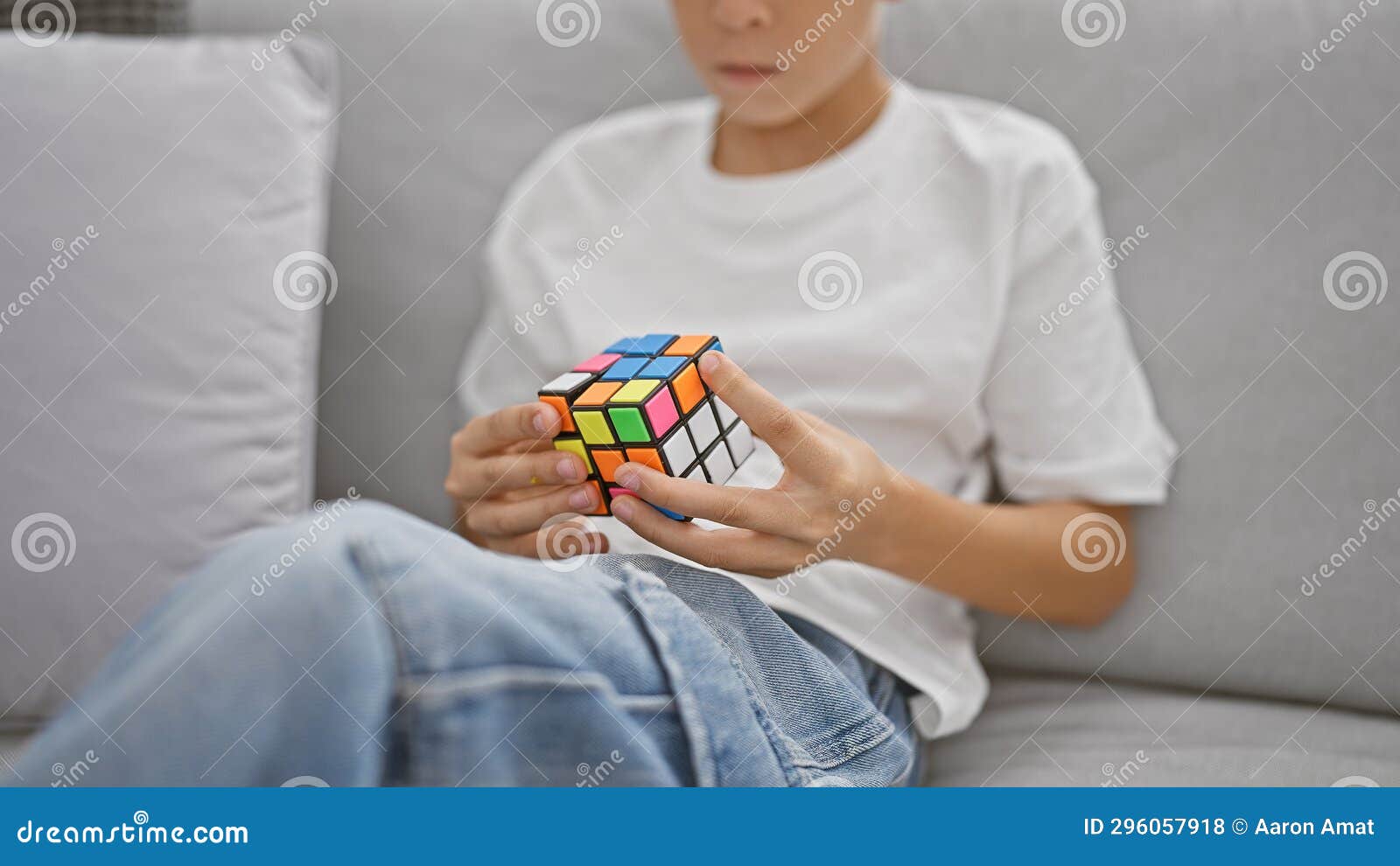 Blond Boy Sitting on Sofa Playing with Rubik Cube at Home Stock Photo ...