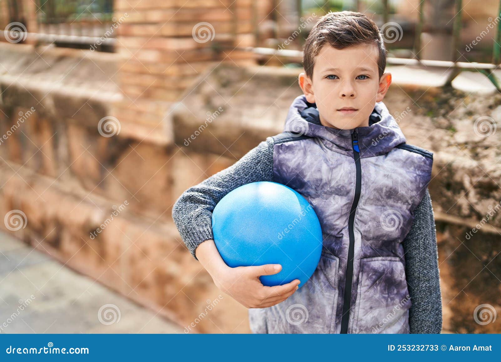 Blond Child Holding Ball with Relaxed Expression at Street Stock Image ...