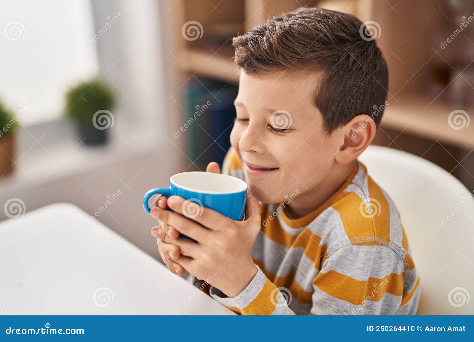 Blond Child Smelling Milk Sitting on Table at Home Stock Photo - Image ...