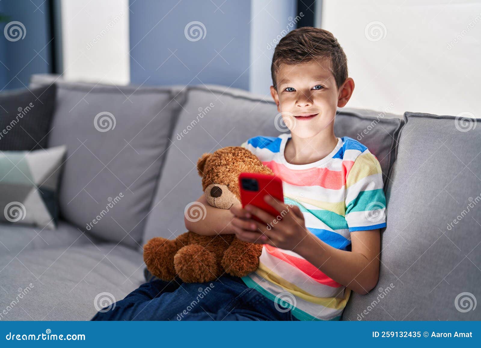 Blond Child Using Smartphone Sitting on Sofa at Home Stock Image ...