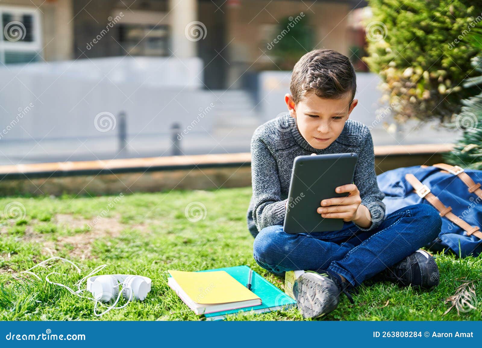 Blond Child Using Touchpad Sitting on Grass at Park Stock Photo - Image ...