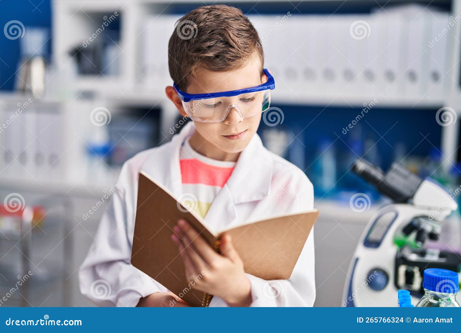 Blond Child Wearing Scientist Uniform Reading Book at Laboratory Stock ...