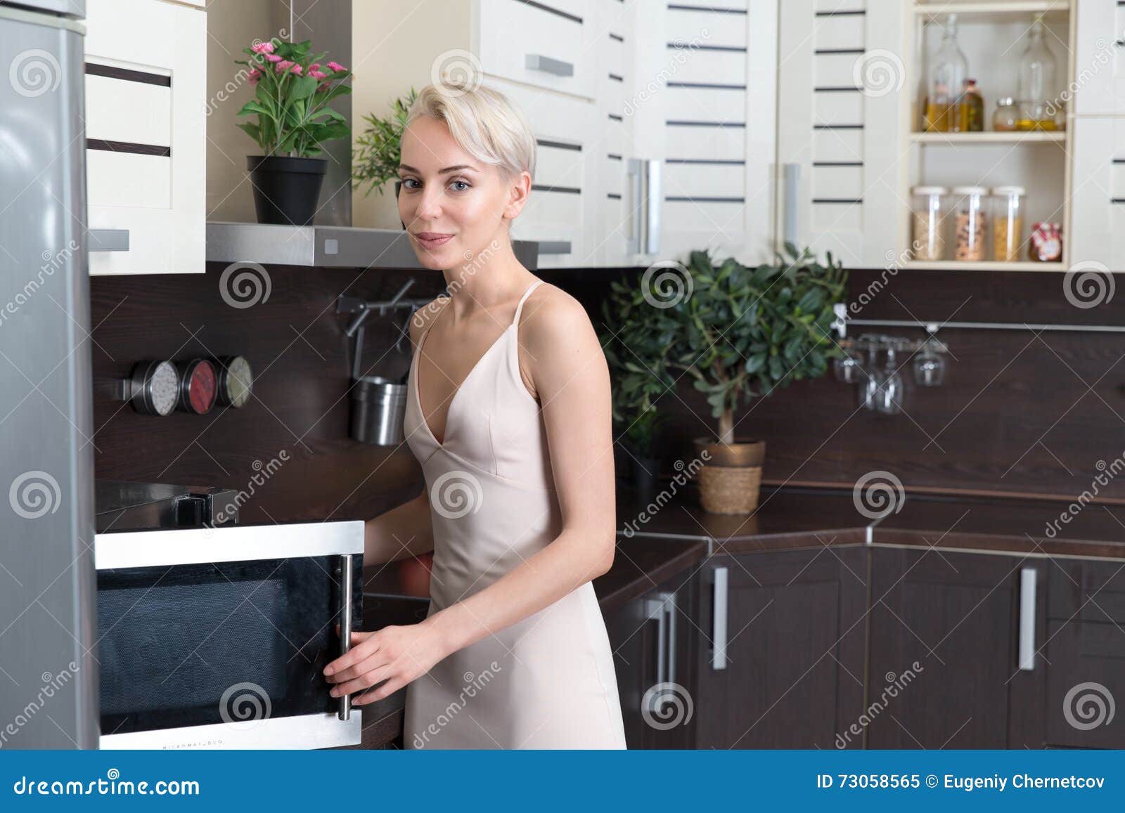 Blond Woman Cooking with a Microwave in Kitchen Stock Image - Image of ...