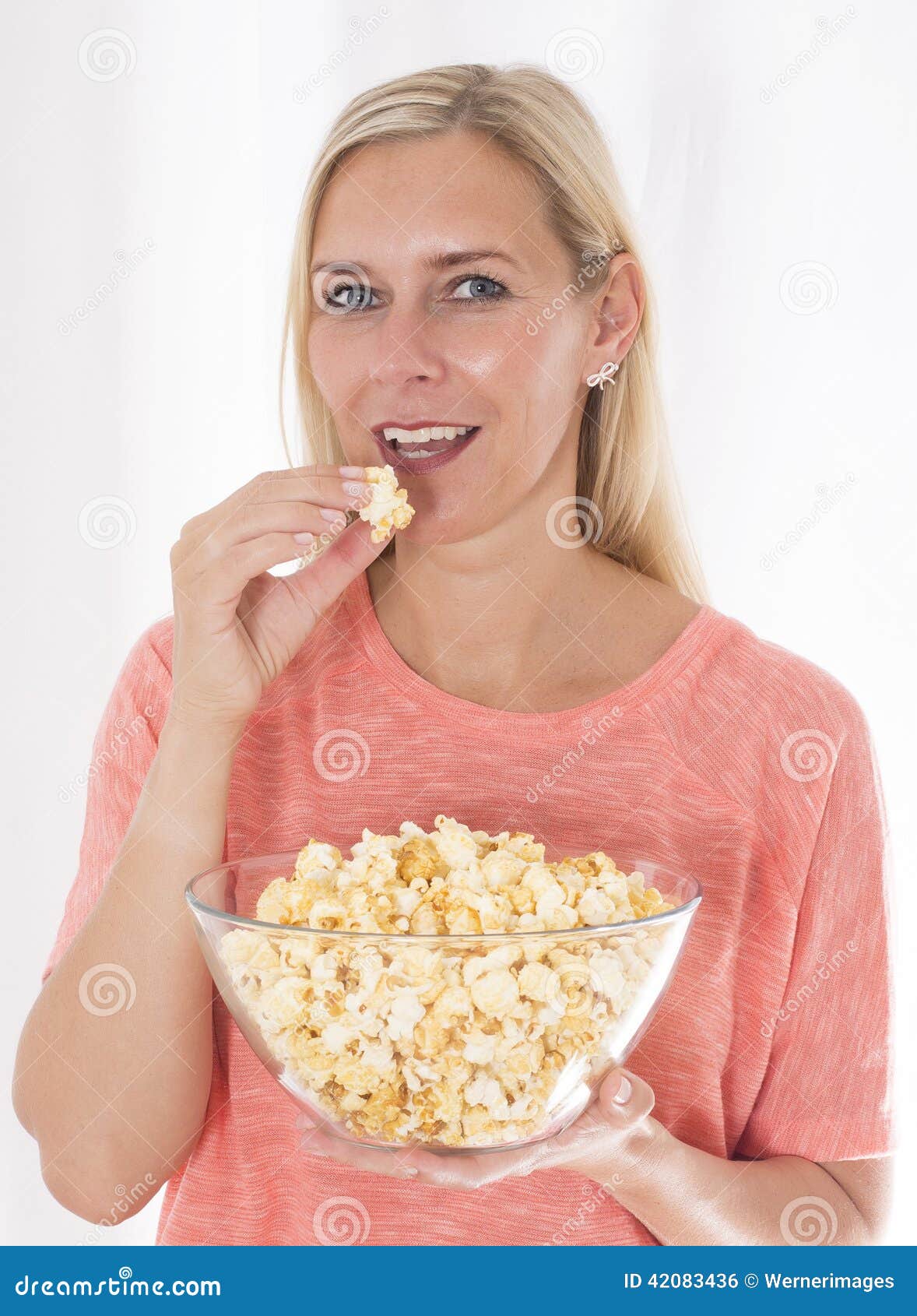 Blond woman eating popcorn stock photo. Image of holding - 42083436