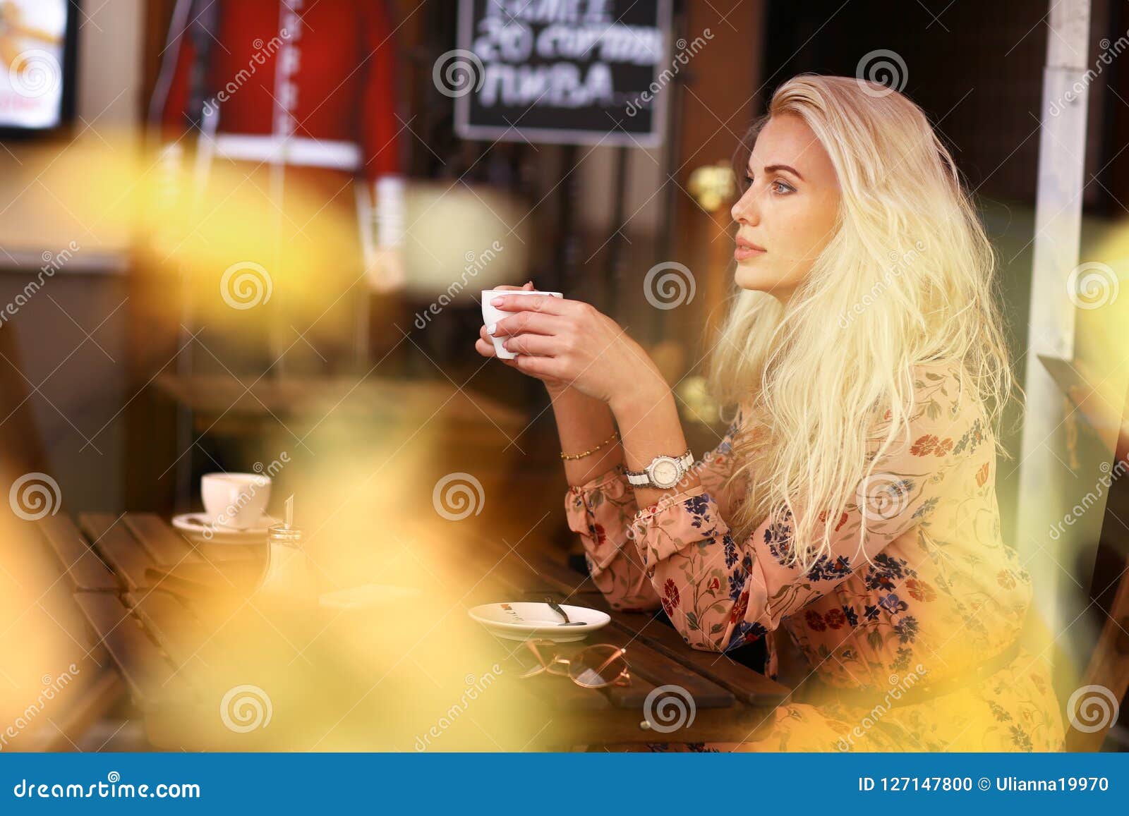 Blond Woman On Lunch Break Sit In Summer Outdoor Cafe With Cup O Stock