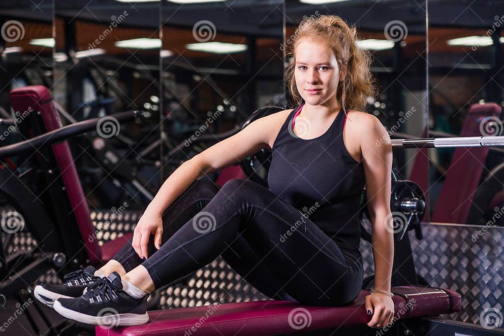 Blonde Bodybuilder Woman Is Sitting In The Gym On The Bench Stock Image