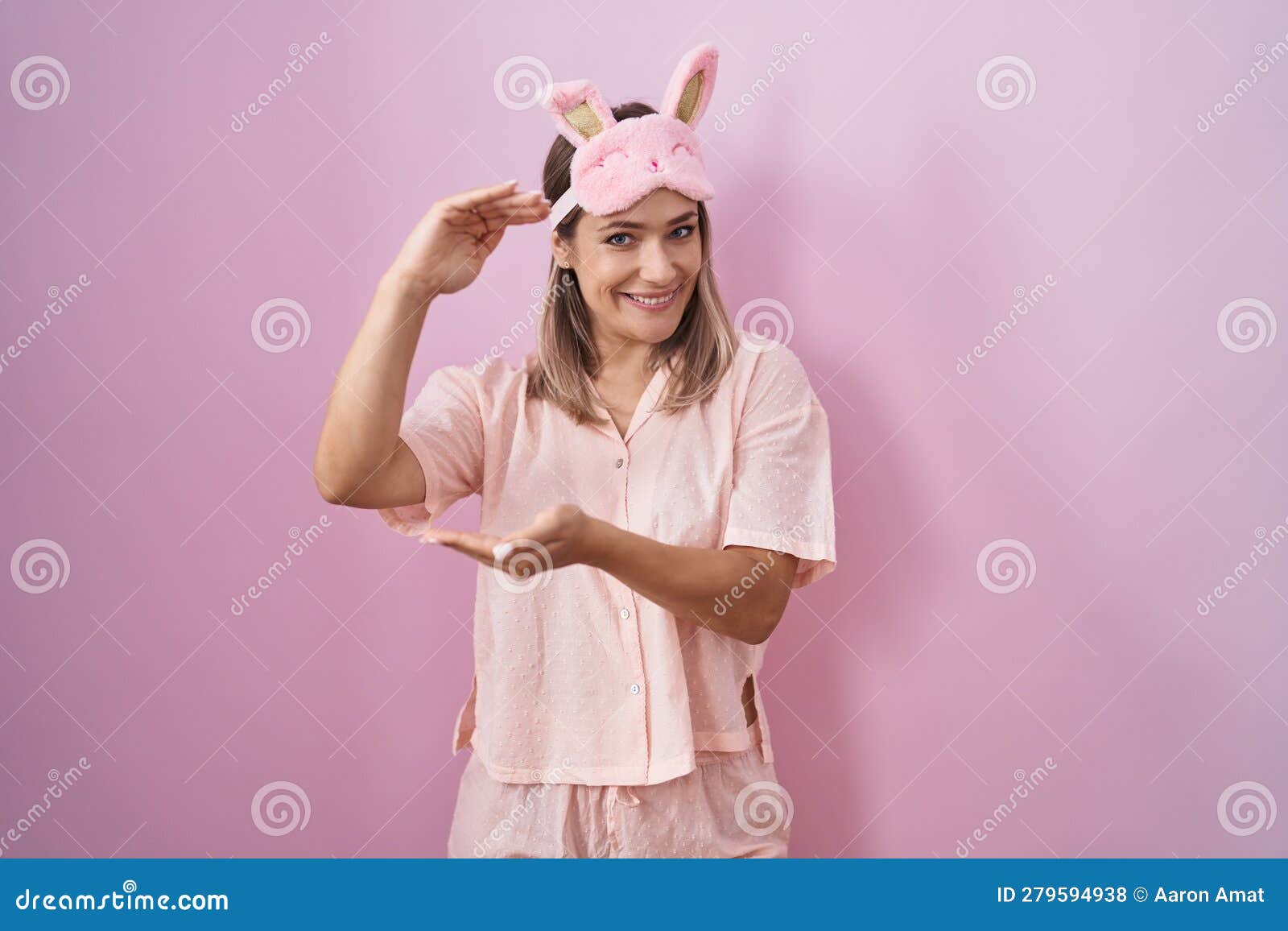 Blonde Caucasian Woman Wearing Sleep Mask And Pajama Gesturing With
