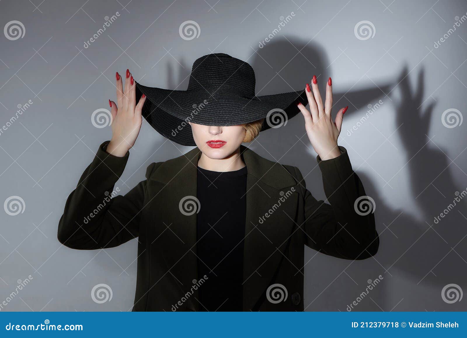 The Blonde Covered Her Eyes with the Brim of Her Black Hat Stock Photo ...
