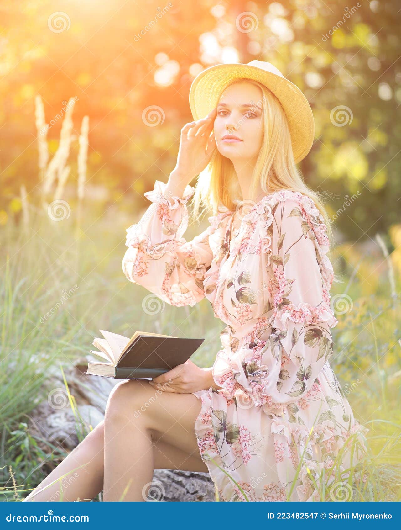 Blonde Girl In The Forest Sitting With A Book In A Hat Stock Image