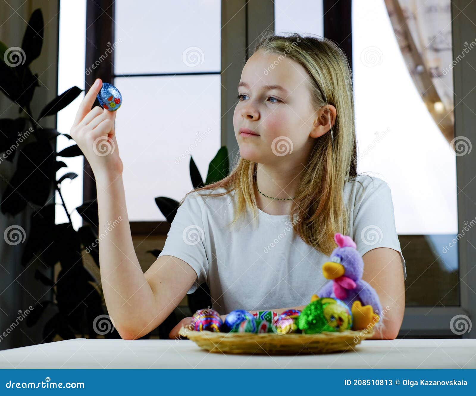 Blonde Girl Holding Chocolate Ester Egg and Looking at Egg Stock Image ...