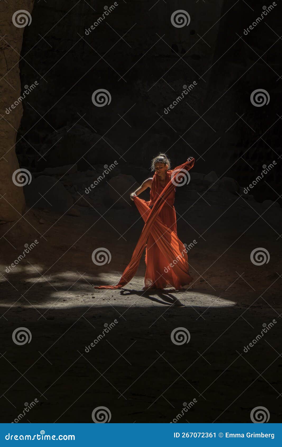 Blonde Girl in Red Dancing in a Natural Cave in the Rays of Light Stock ...