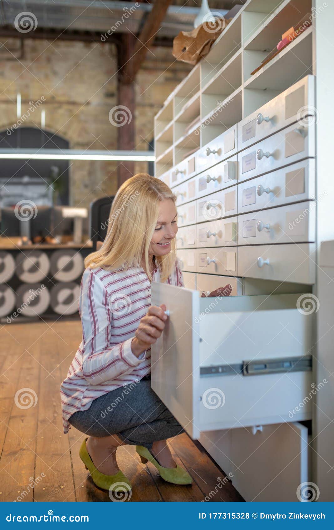 Blonde Woman Crouching, Opening Drawer, Looking Inside Stock Photo ...