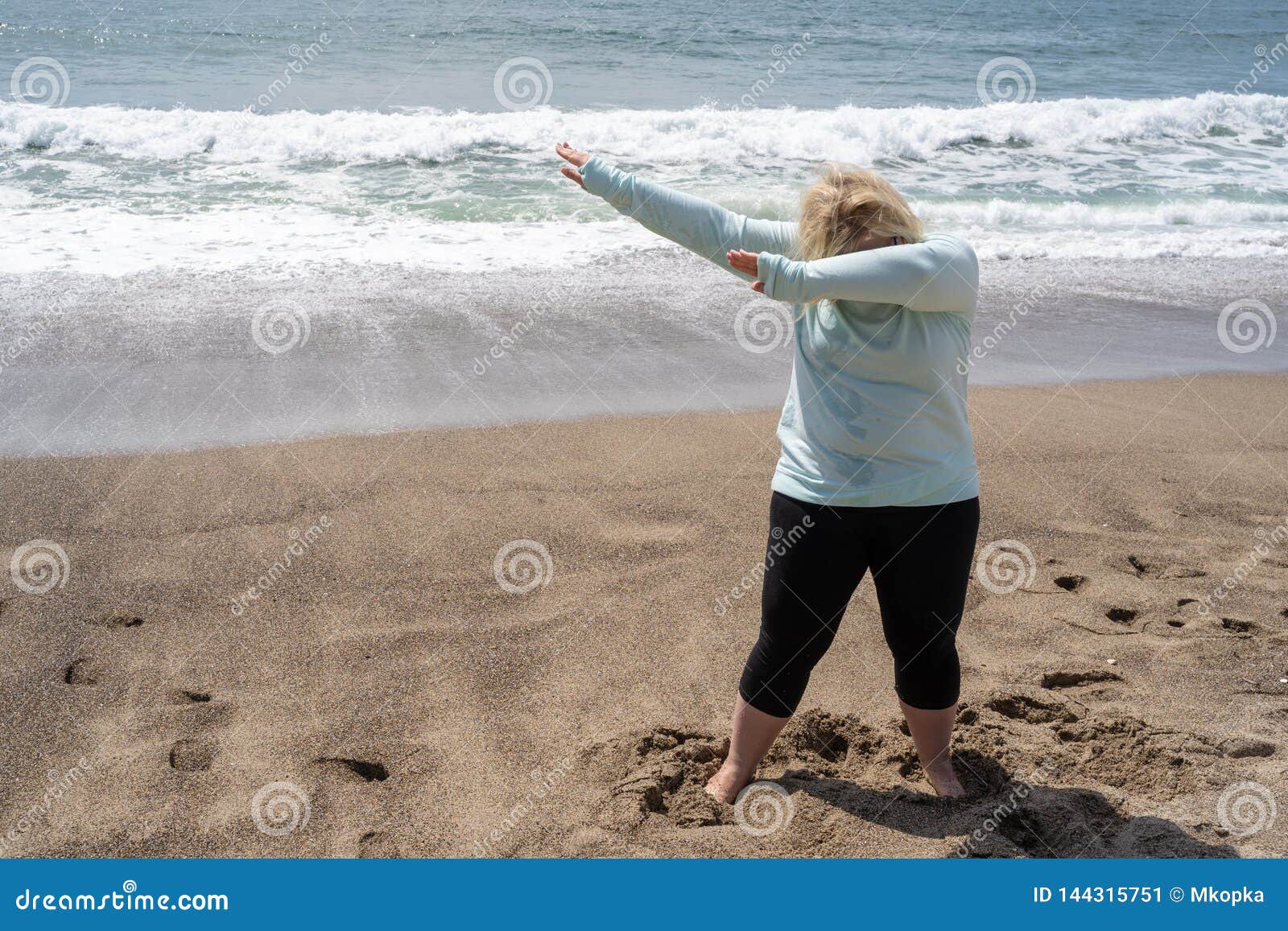 Blonde Woman Does a Dabbing Dance Move on the Beach Stock Image - Image ...