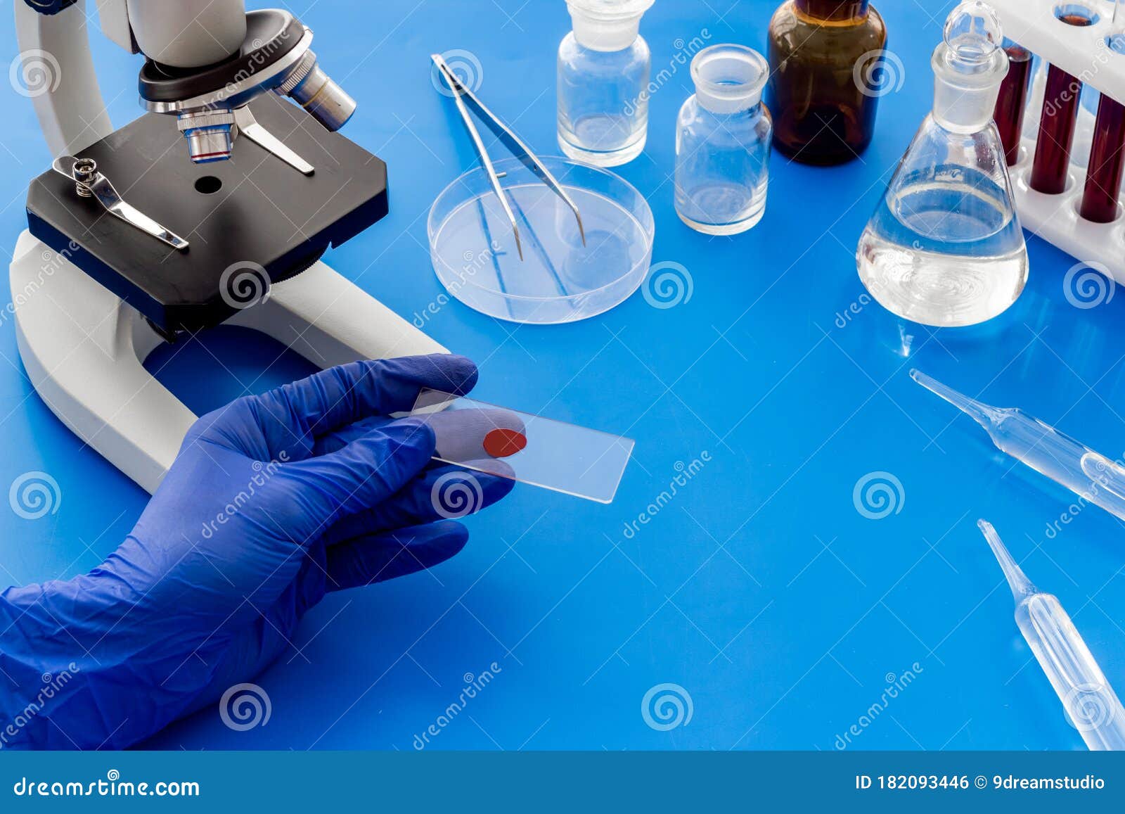 Blood Testing with Microscope in Laboratory. Sample in Hands on Blue ...