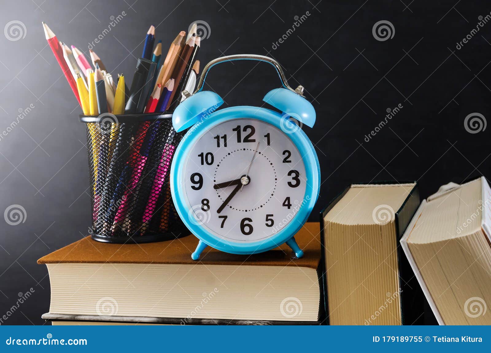 Blue Alarm Clock and Colored Pencils on a Stack of Books. Education ...