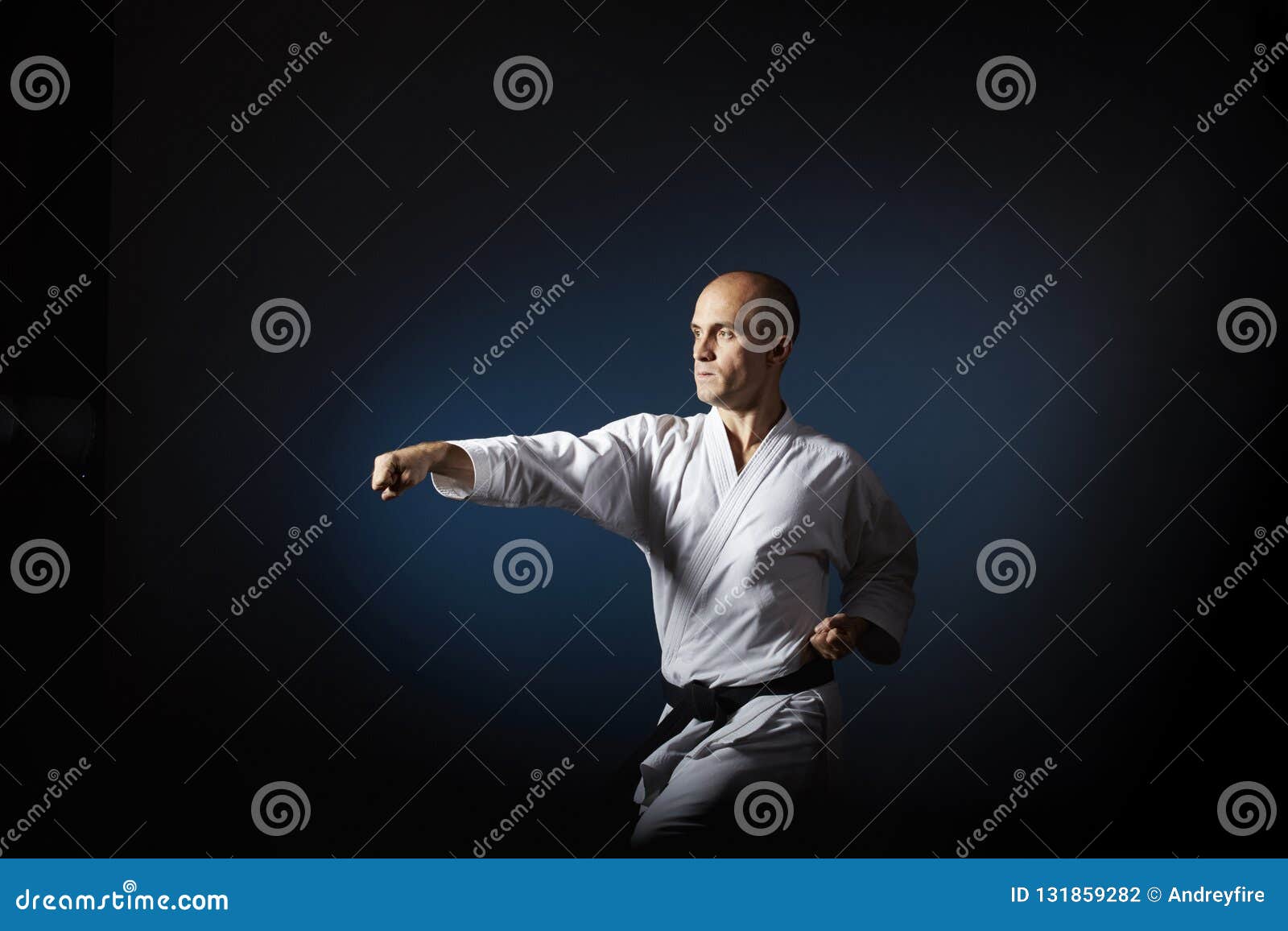 On a Blue Background with a Gradient, an Athlete with a Black Belt Does ...