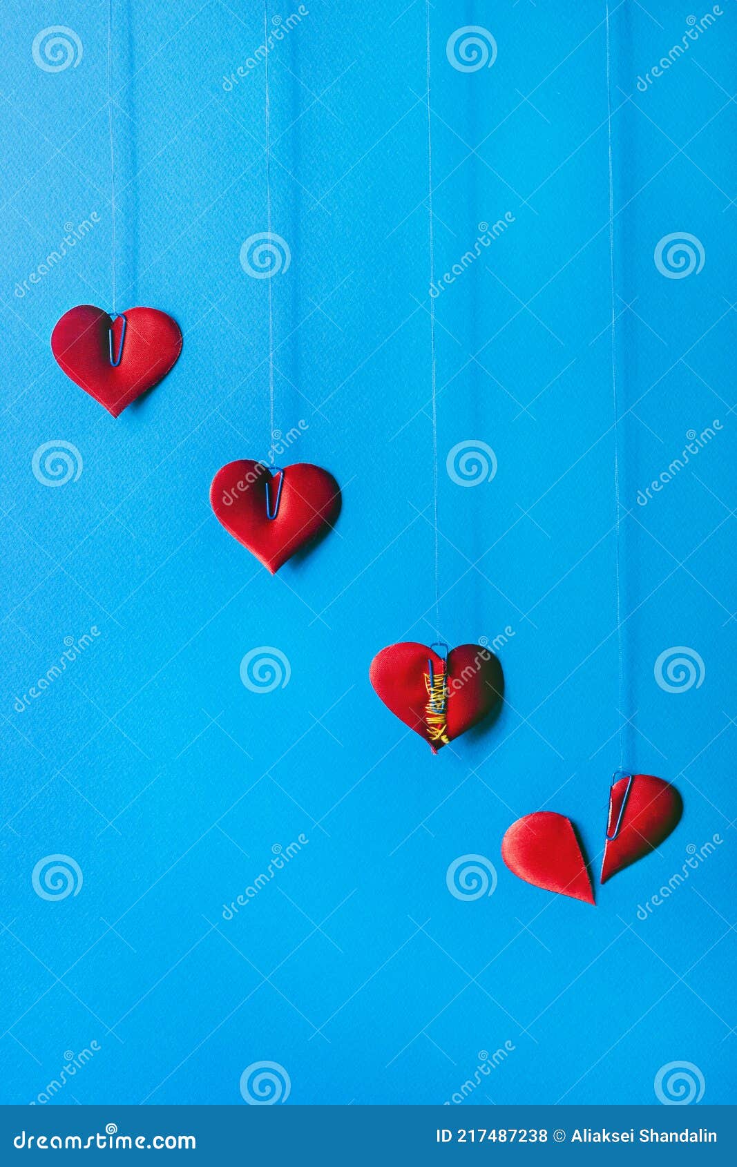 On a Blue Background, Red Hearts Hang on Strings Stock Photo - Image of ...