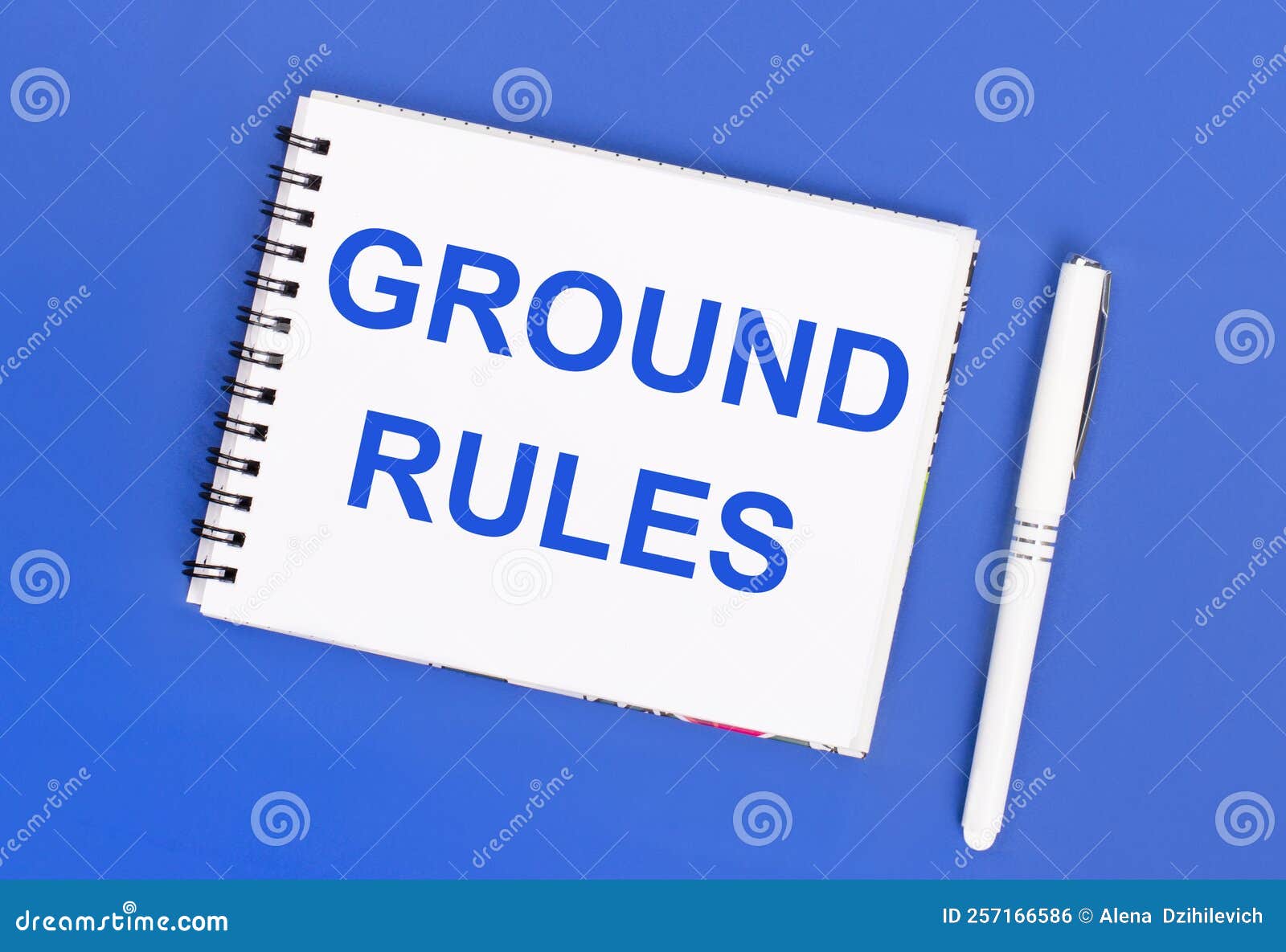 On a Blue Background, a White Ballpoint Pen and a White Notepad with ...