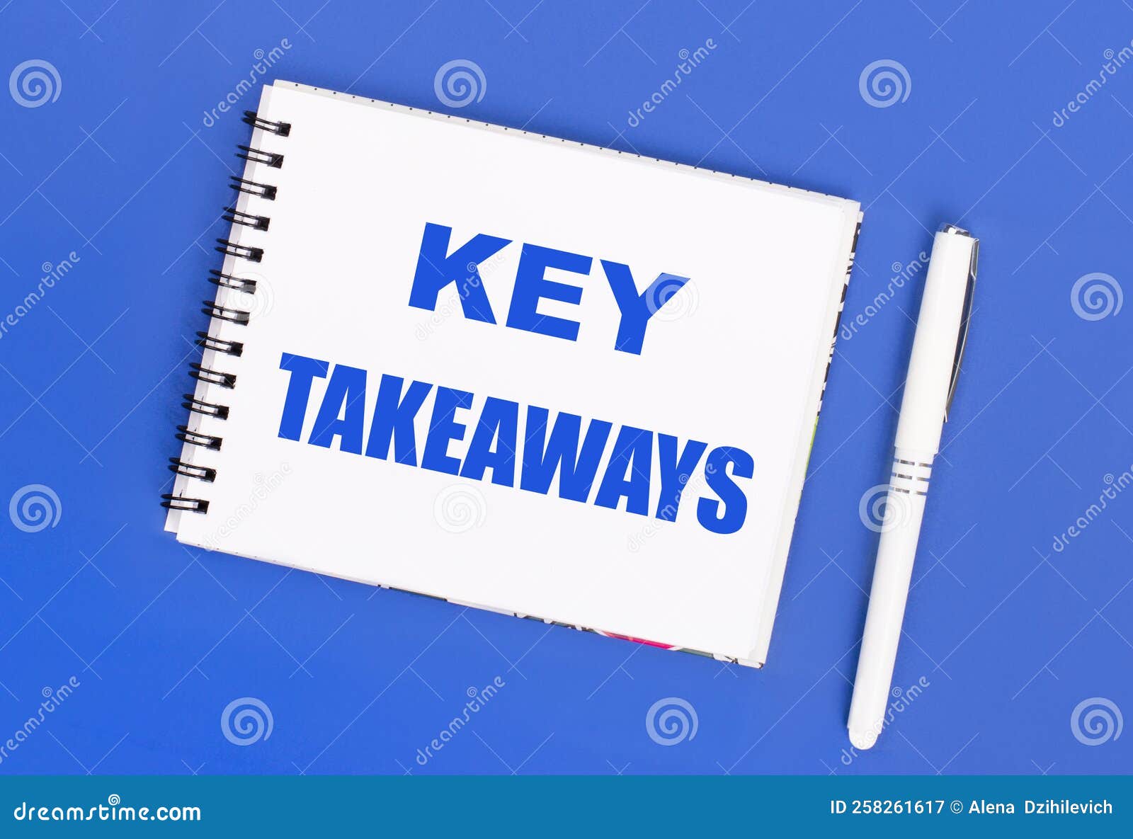 On a Blue Background, a White Ballpoint Pen and a White Notepad with ...