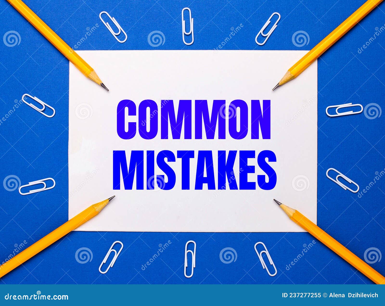 On a Blue Background, White Paper Clips, Yellow Pencils and a White ...