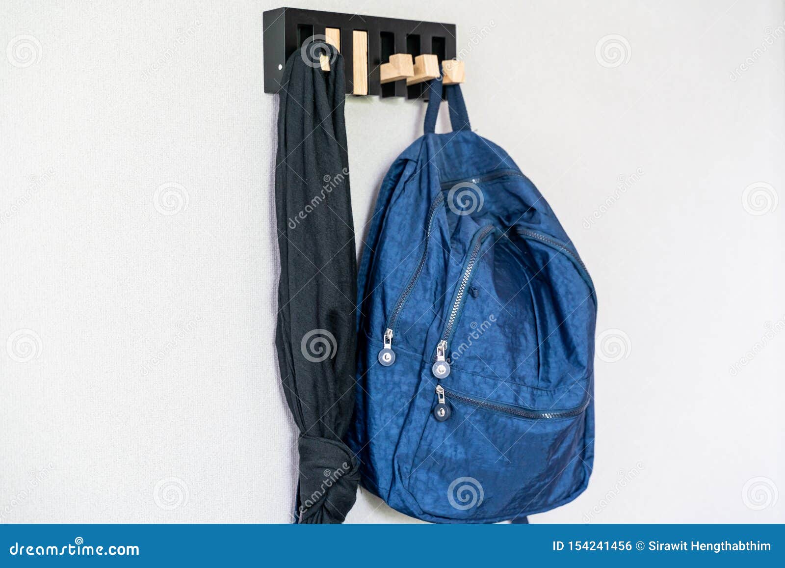 Blue Backpack is Hanging on the Wooden Hanger on White Wall Stock Photo ...