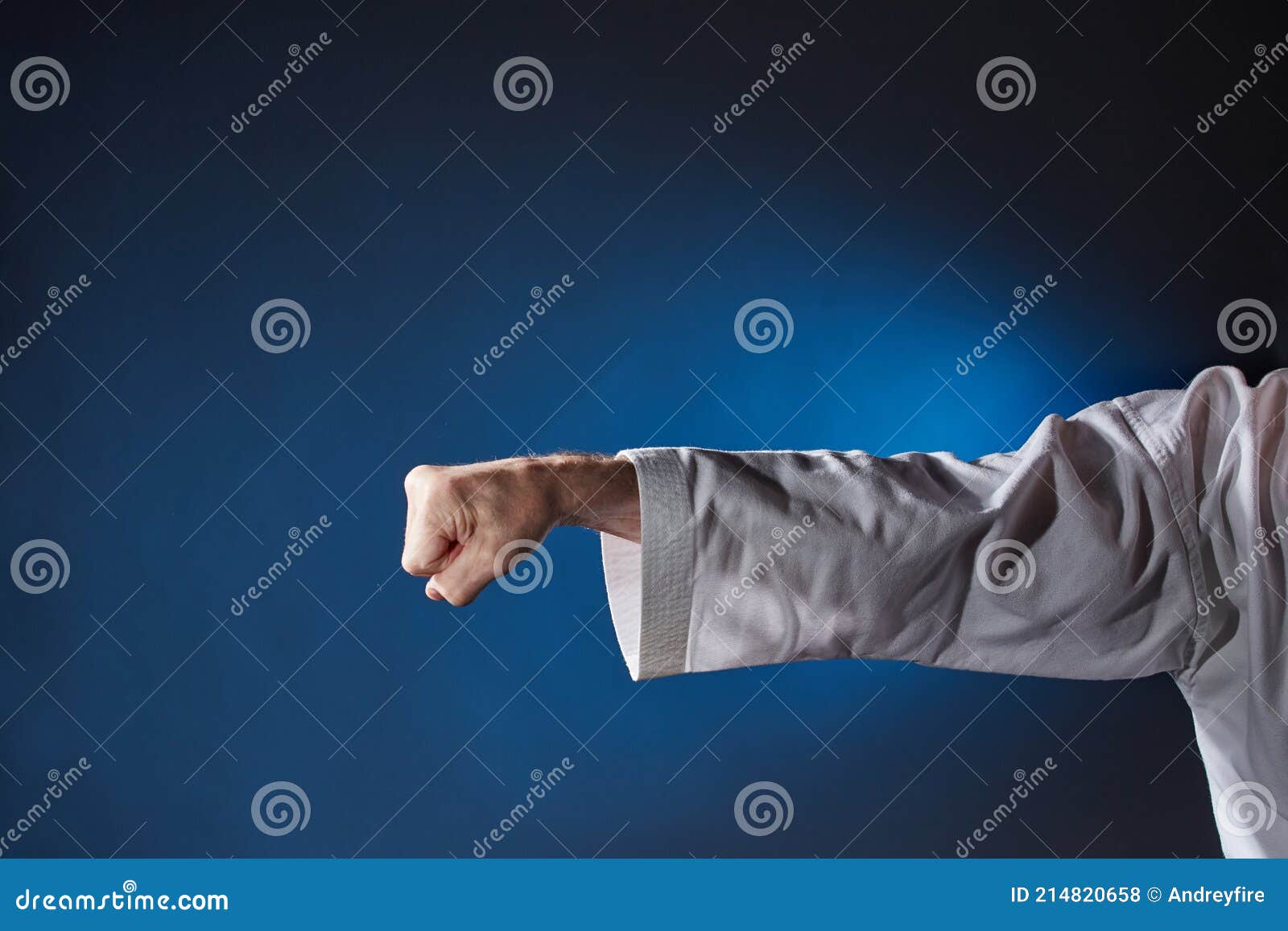 On a Blue Blurred Background, an Athlete Performs a Punch Arm Stock ...